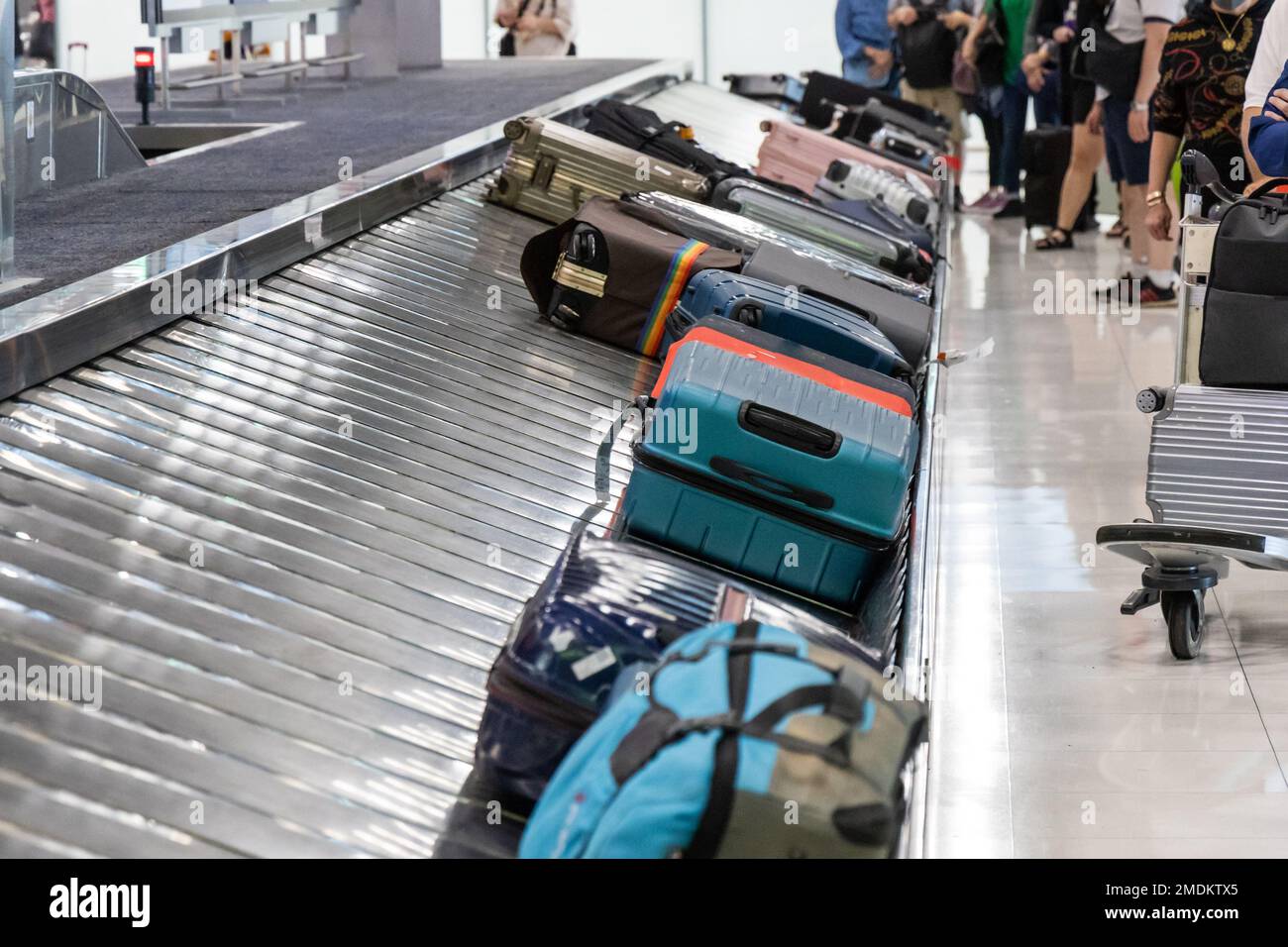 Baggage luggage at airport arrival carousel with passengers awiating to ...