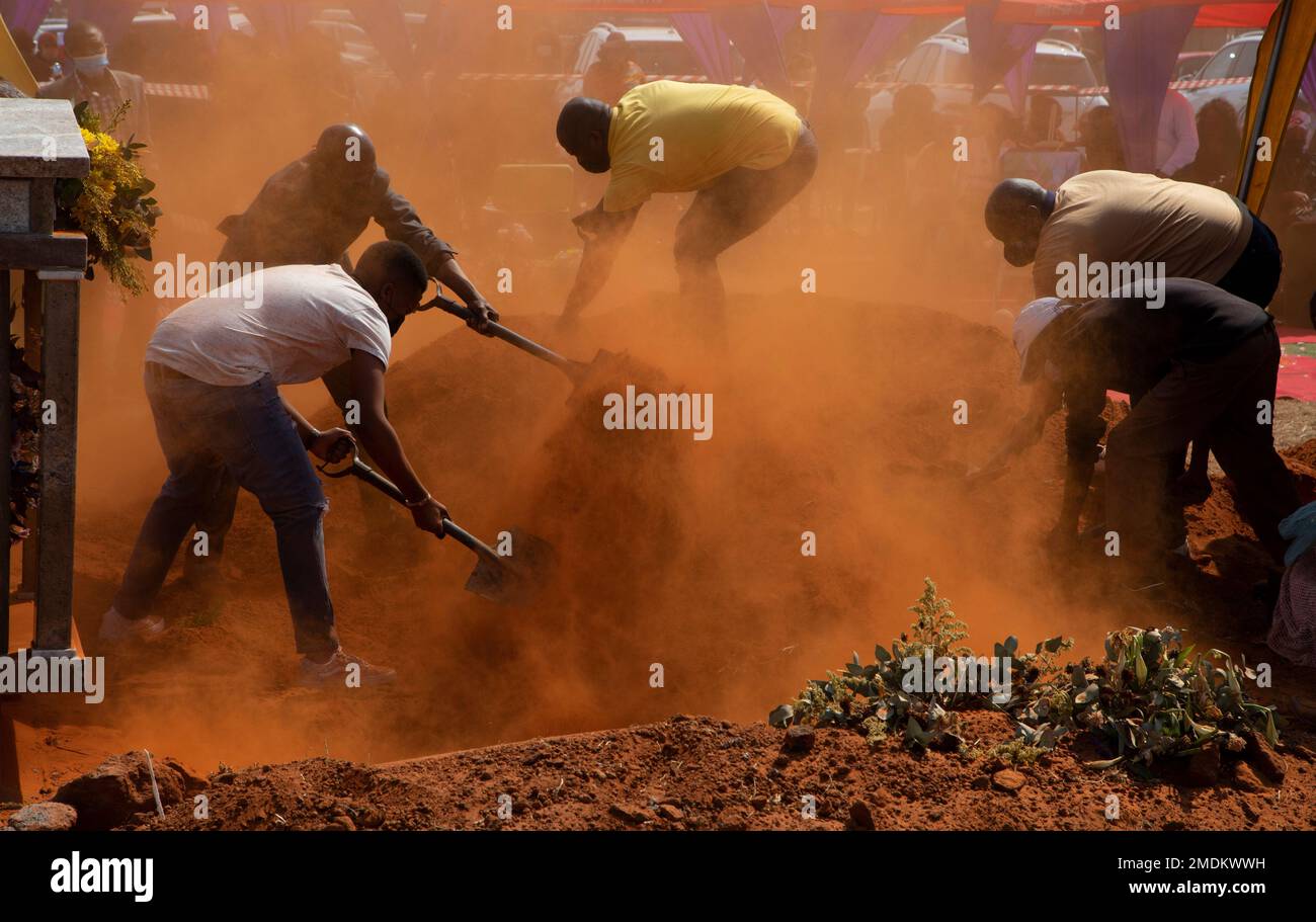 Mourners fill the grave at a funeral at the South Park Cemetery in ...