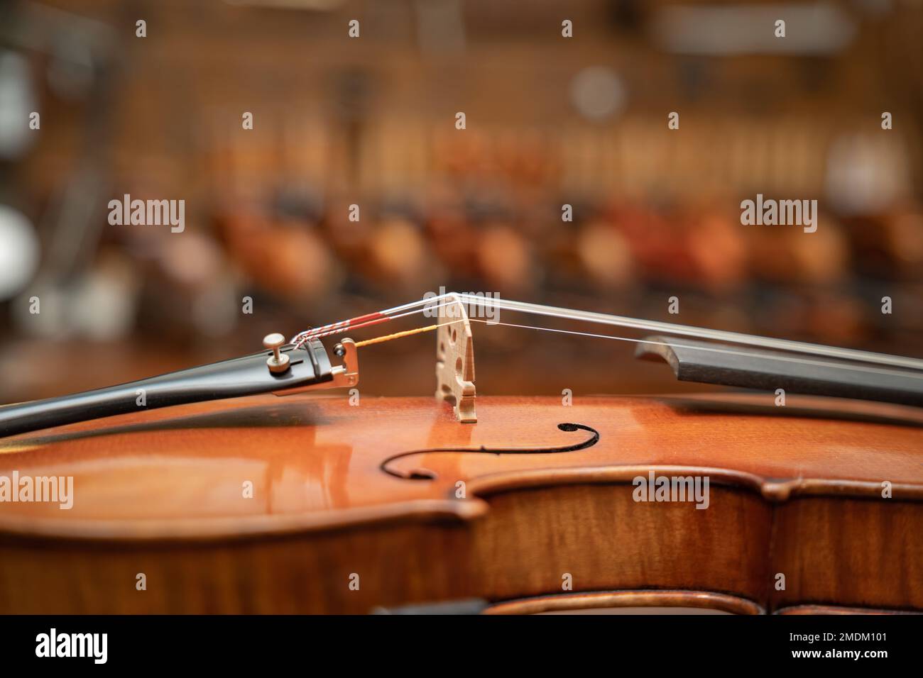 A shallow focus of the violin bridge with restoration tools hang on the ...