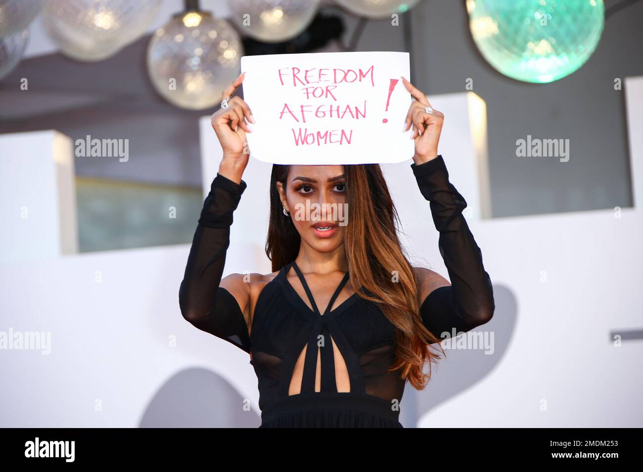 Maya Talem poses for photographers, with a placard that says 'Freedom ...