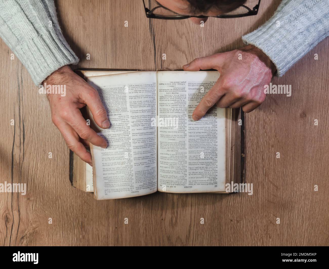 Caen, France 2023. Man reading an old book top view, wooden table Stock ...