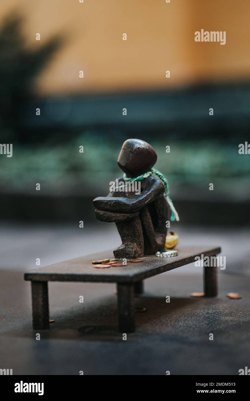 A vertical shot of the smallest sitting iron boy statue in Stockholm ...