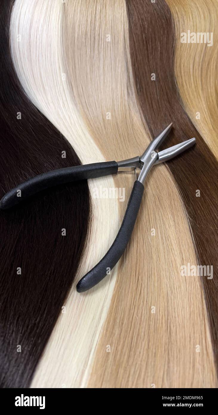 Strands of natural hair in different colors for extensions with tools ...