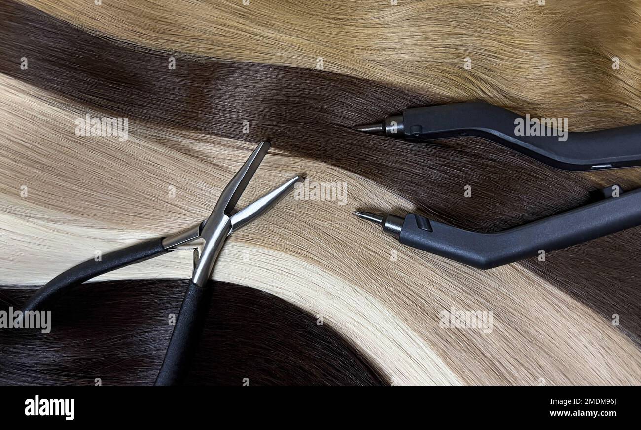 Strands of natural hair in different colors for extensions with tools ...