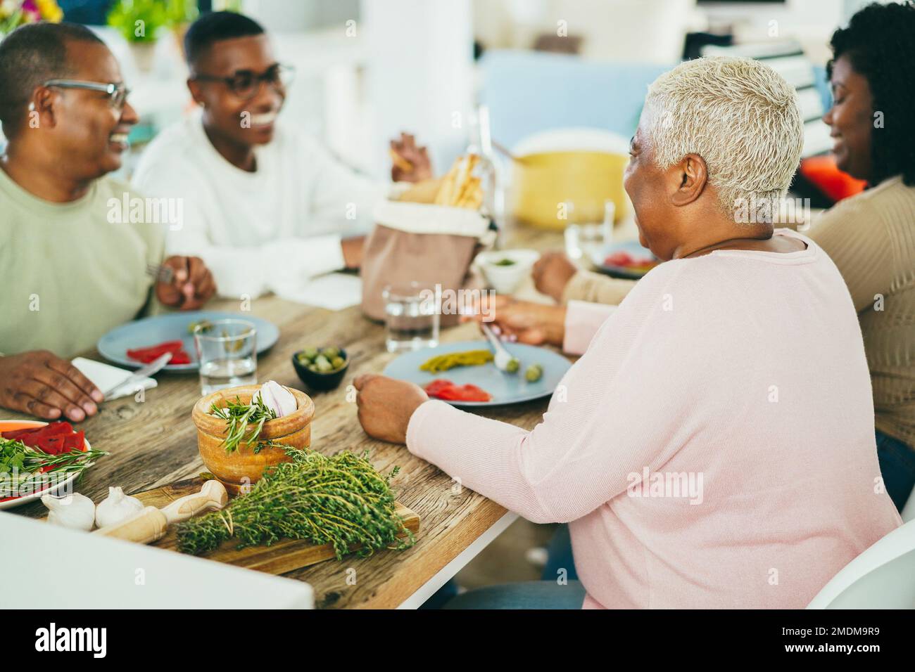 Happy african family eating lunch together at home - Focus on mother ...