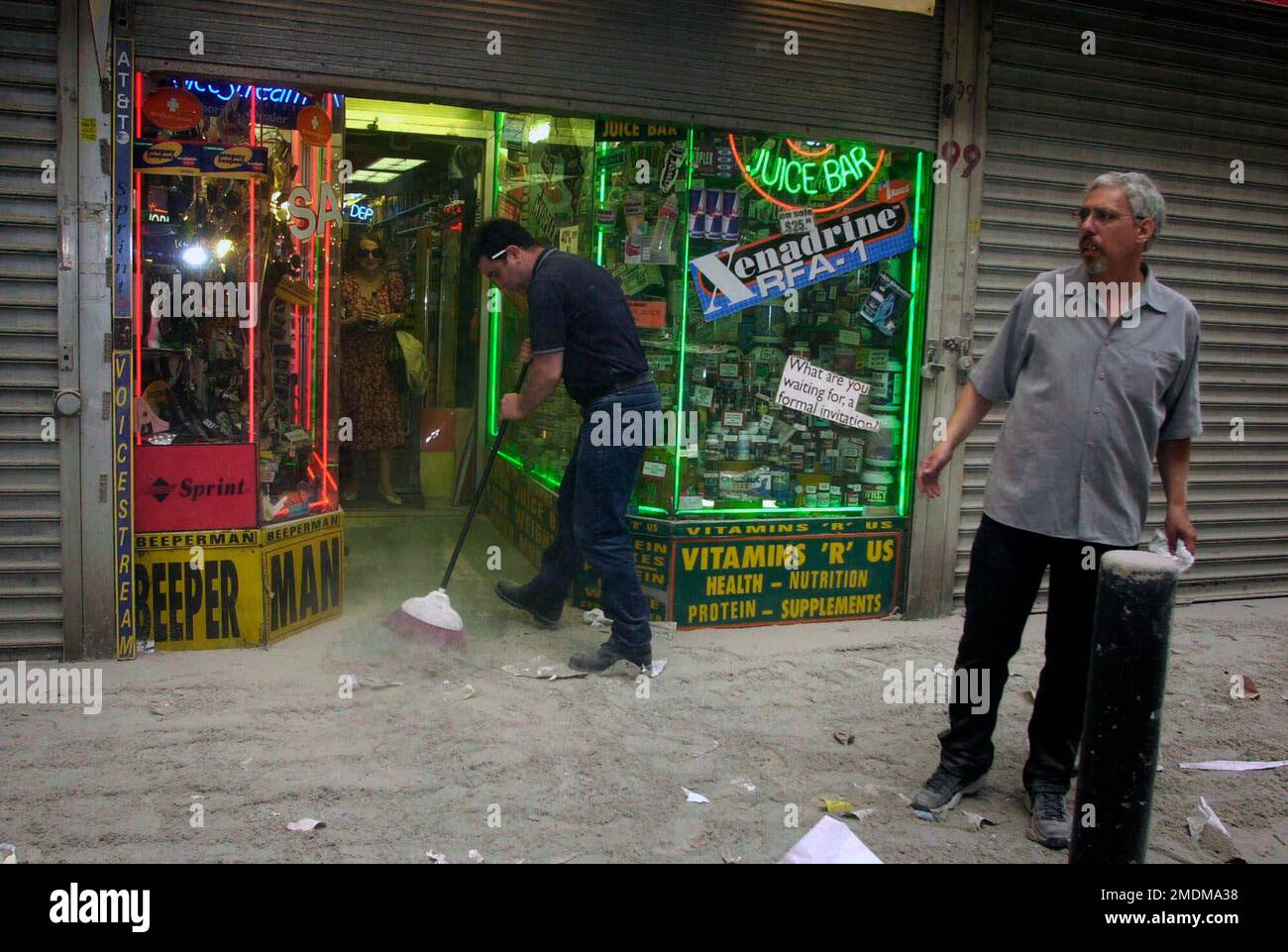 Harry Shasho sweeps up before being evacuated from his vitamin store ...
