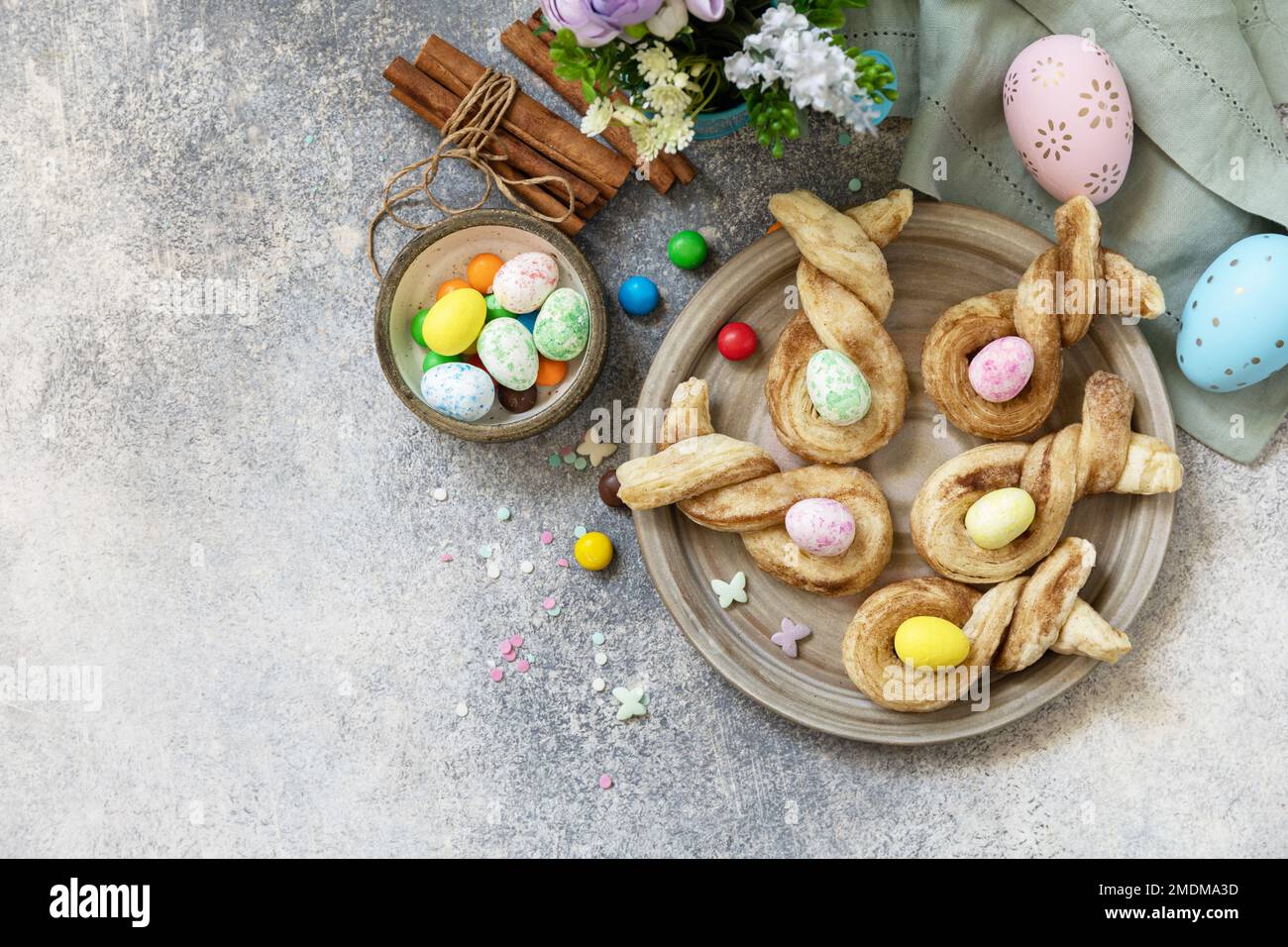 Easter rabbit-shaped buns puff pastry with cinnamon on a stone tabletop ...