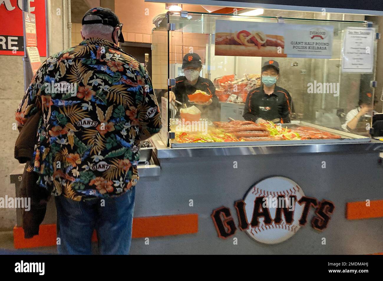 A fan buys food from a vendor at Oracle Park before a baseball game ...