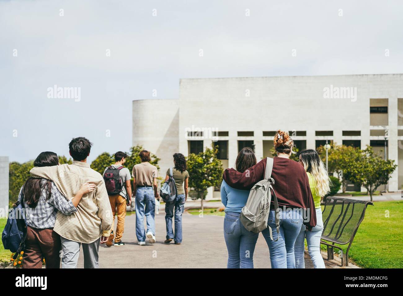 Young group of friends having fun outside with school building on ...
