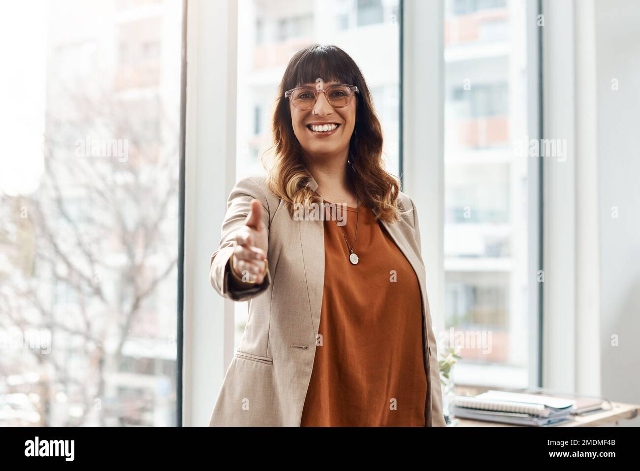 Lets shake on it. Portrait of a cheerful young businesswoman reaching ...