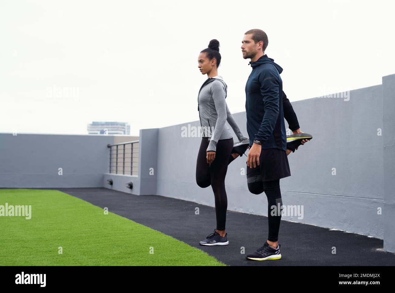 Staying in tip top shape. a sporty young man and woman stretching while ...