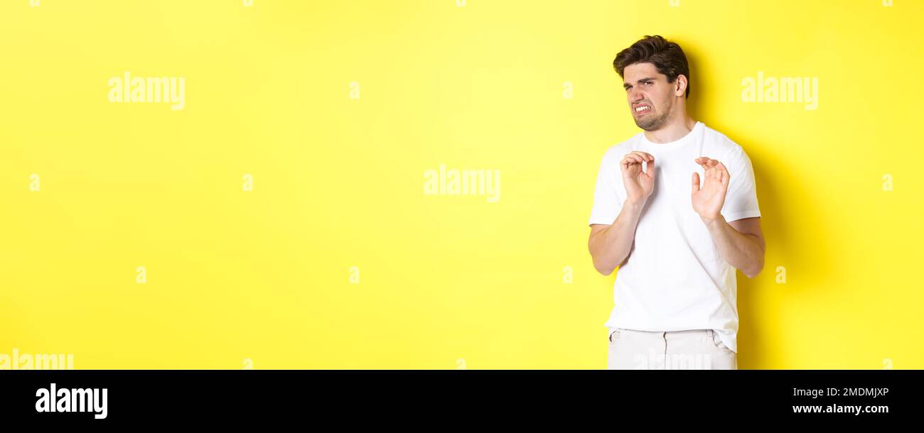 Digusted guy refusing and grimacing, looking at something with aversion ...