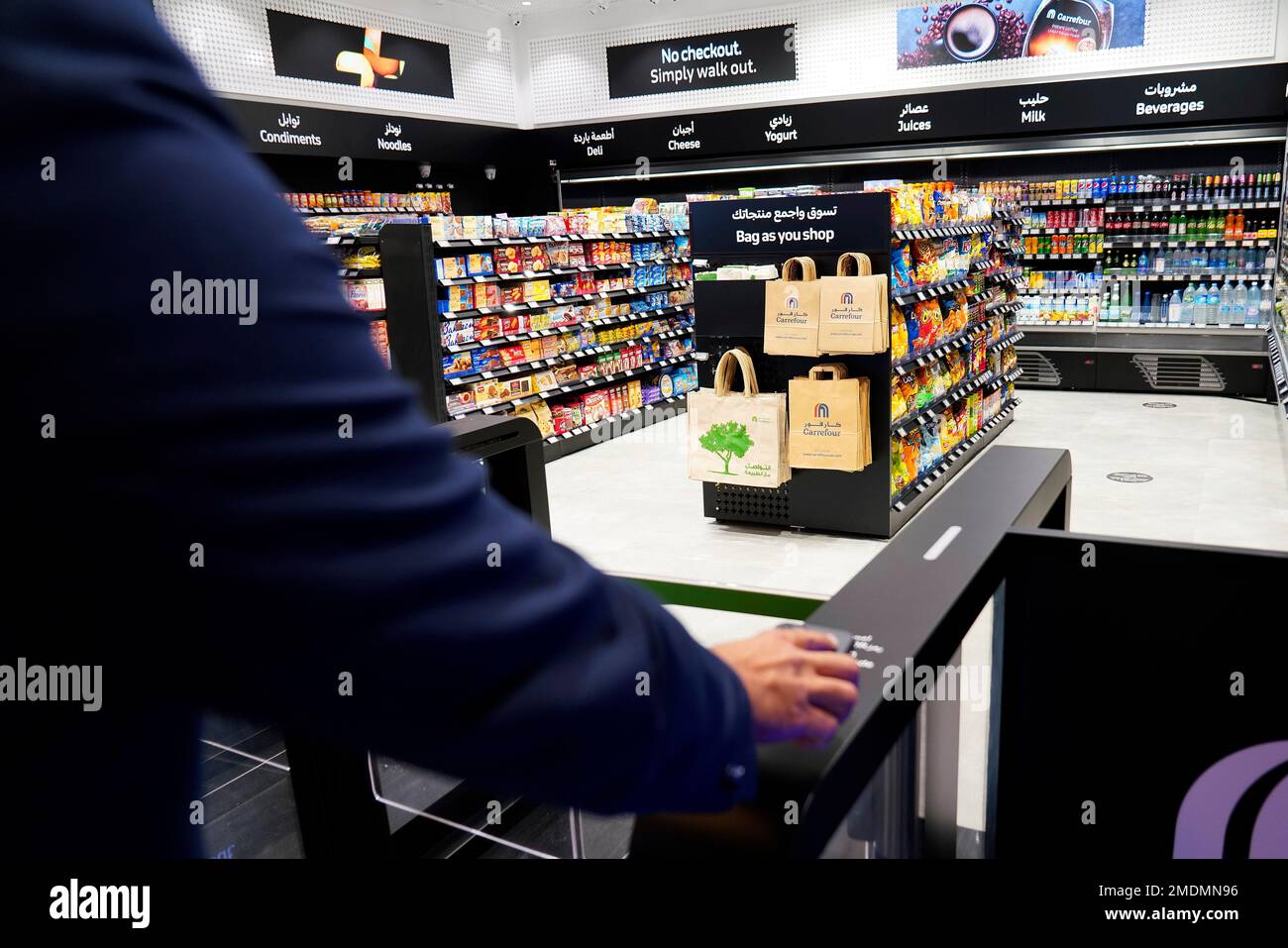 A man uses a QR code on a mobile phone to enter Carrefour's new cashier ...