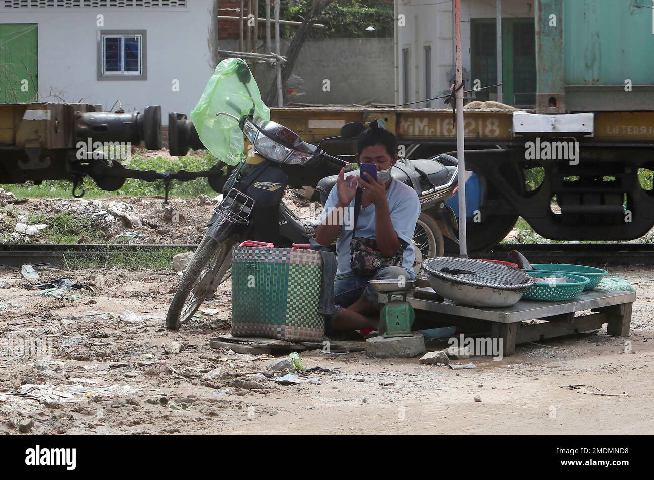 A fish vendor sits at her a stall along the train tracks in Tuol Leap ...