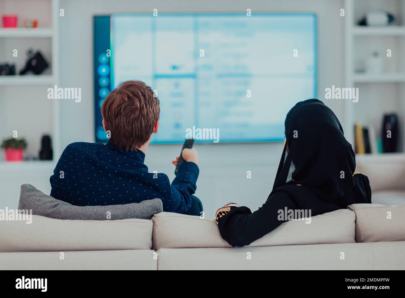 Young muslim couple woman wearing islamic hijab clothes sitting on sofa ...