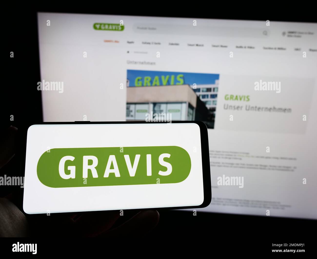 Person holding mobile phone with logo of Gravis ...