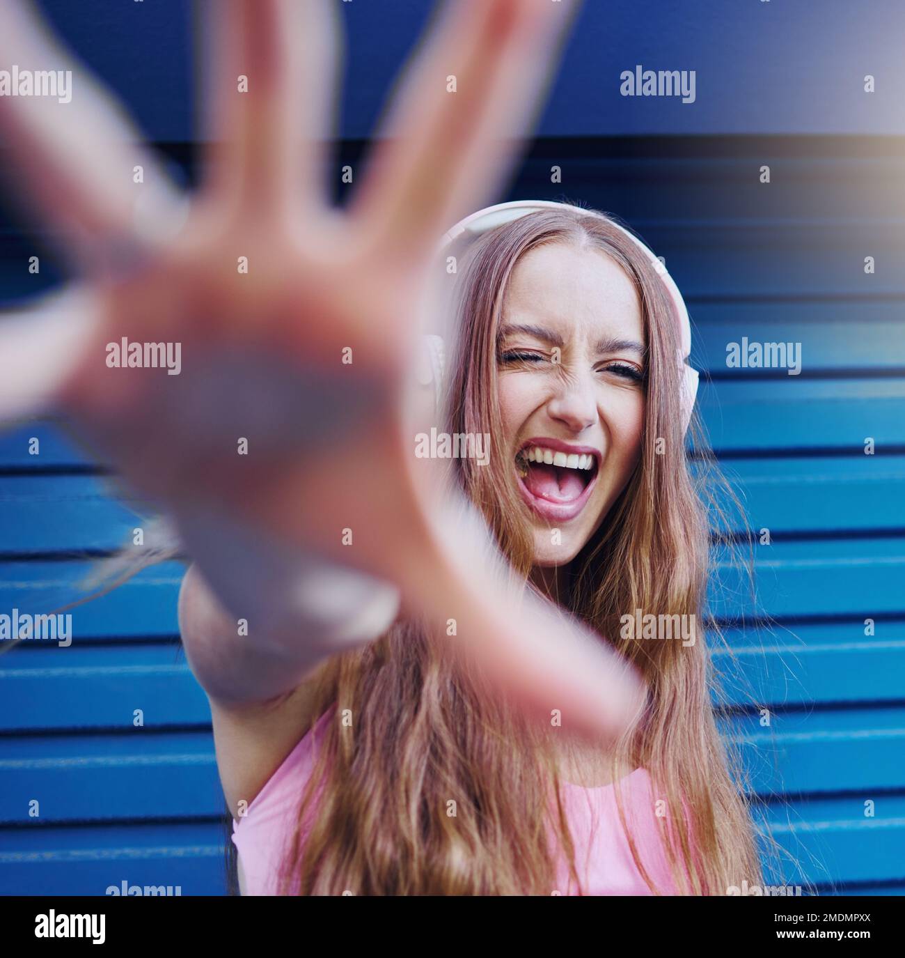 Music, dance and wink with a woman reaching on a blue background while ...