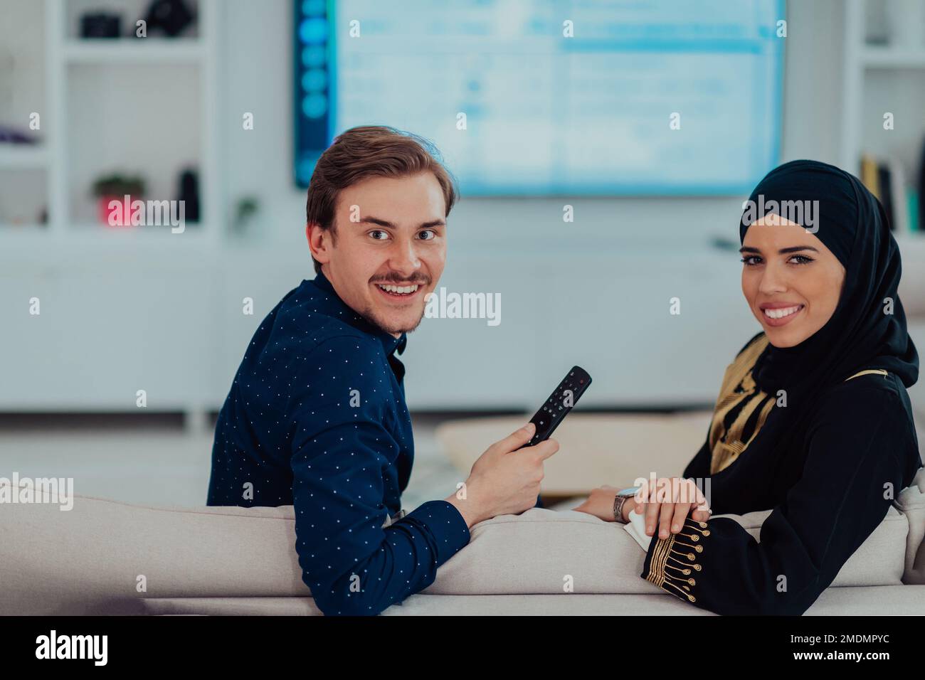 Young muslim couple woman wearing islamic hijab clothes sitting on sofa ...
