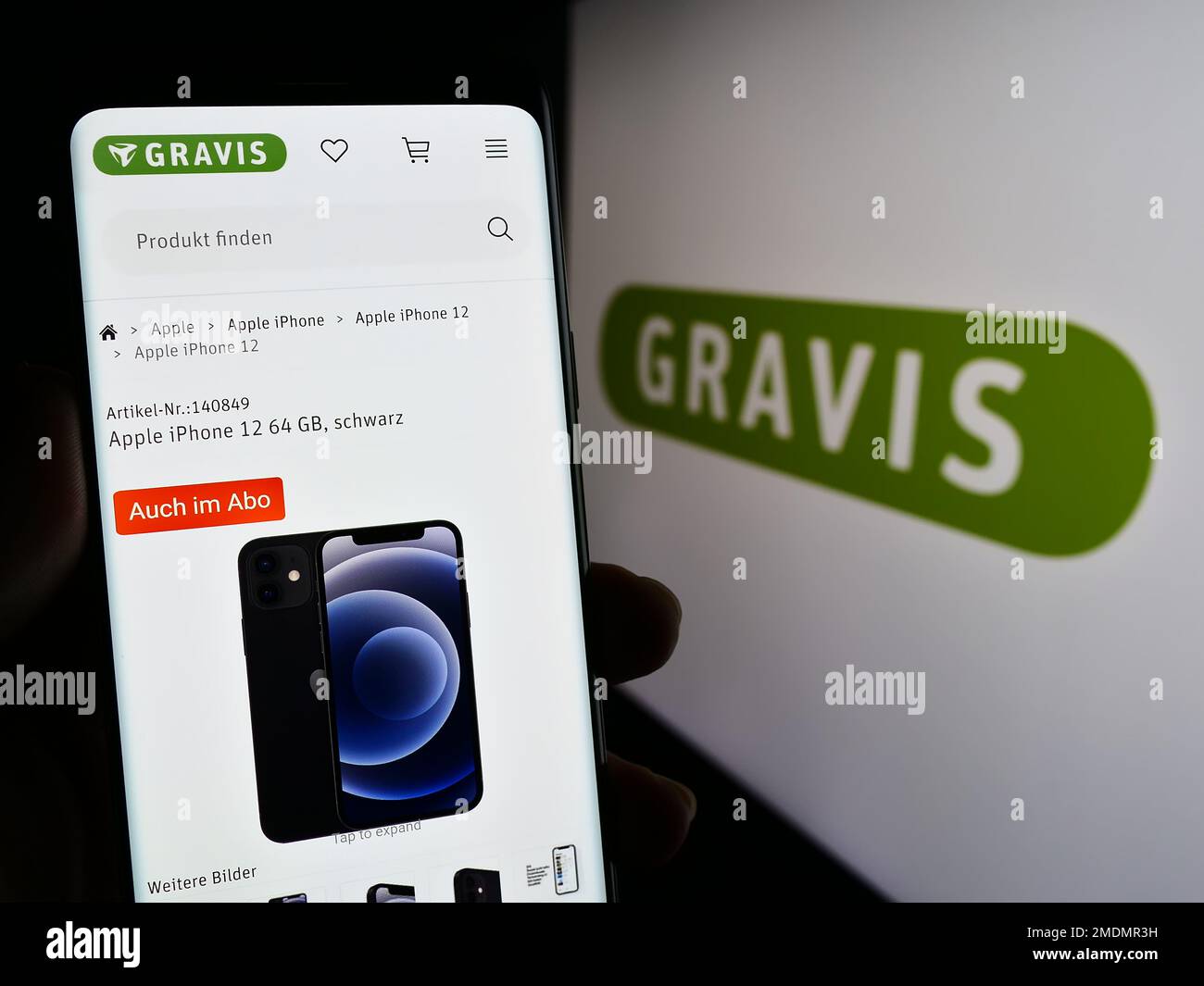 Person holding cellphone with webpage of Gravis ...