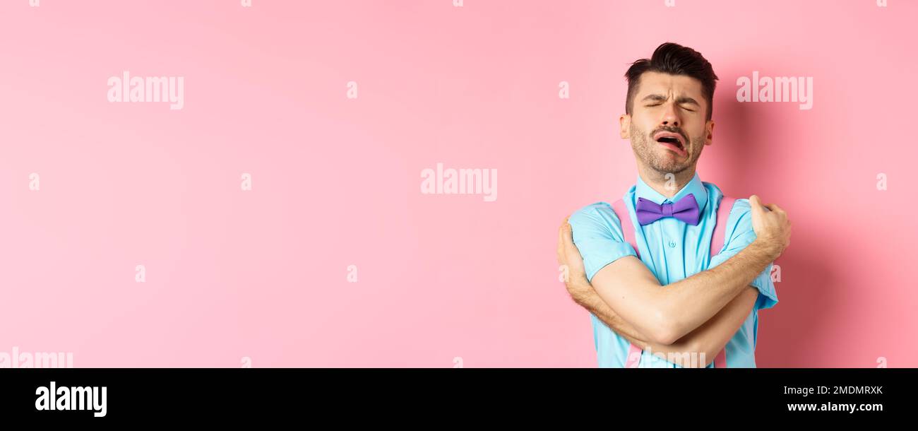 Crying guy hugging himself, feeling sad and lonely, standing unhappy on ...