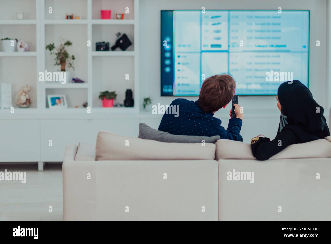 Young muslim couple woman wearing islamic hijab clothes sitting on sofa ...