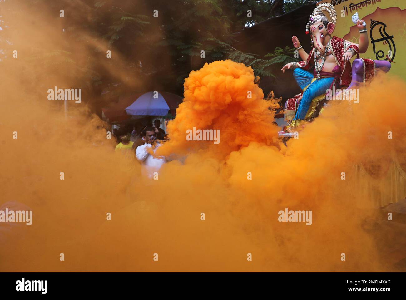 Devotees light firecrackers as an idol of the elephant-headed Hindu god ...