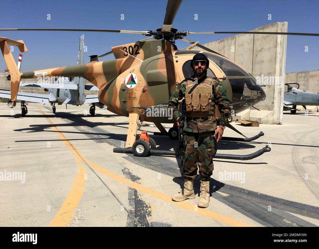 A Taliban fighter stands guard near Afghan military aircraft after the ...