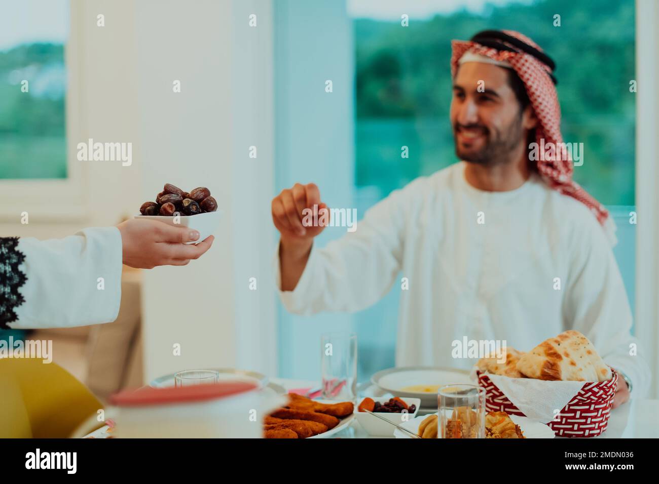 Modern multiethnic muslim family sharing a bowl of dates while enjoying ...