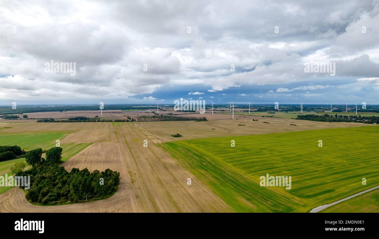 Wind turbines on vast agricultural land with big clouds in the ...
