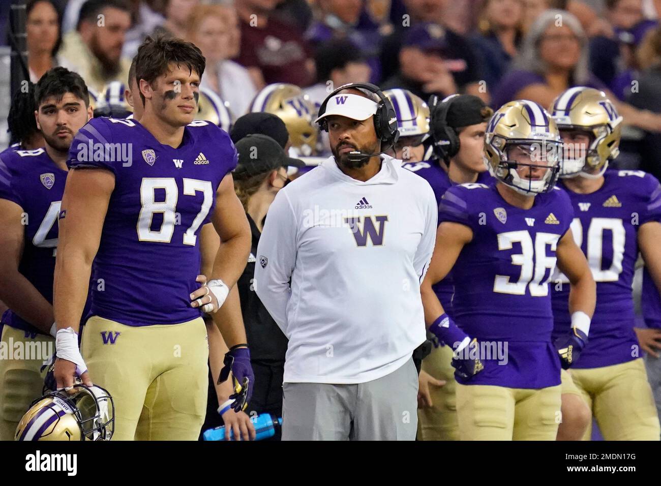 Washington head coach Jimmy Lake, center, stands with teammates on the ...