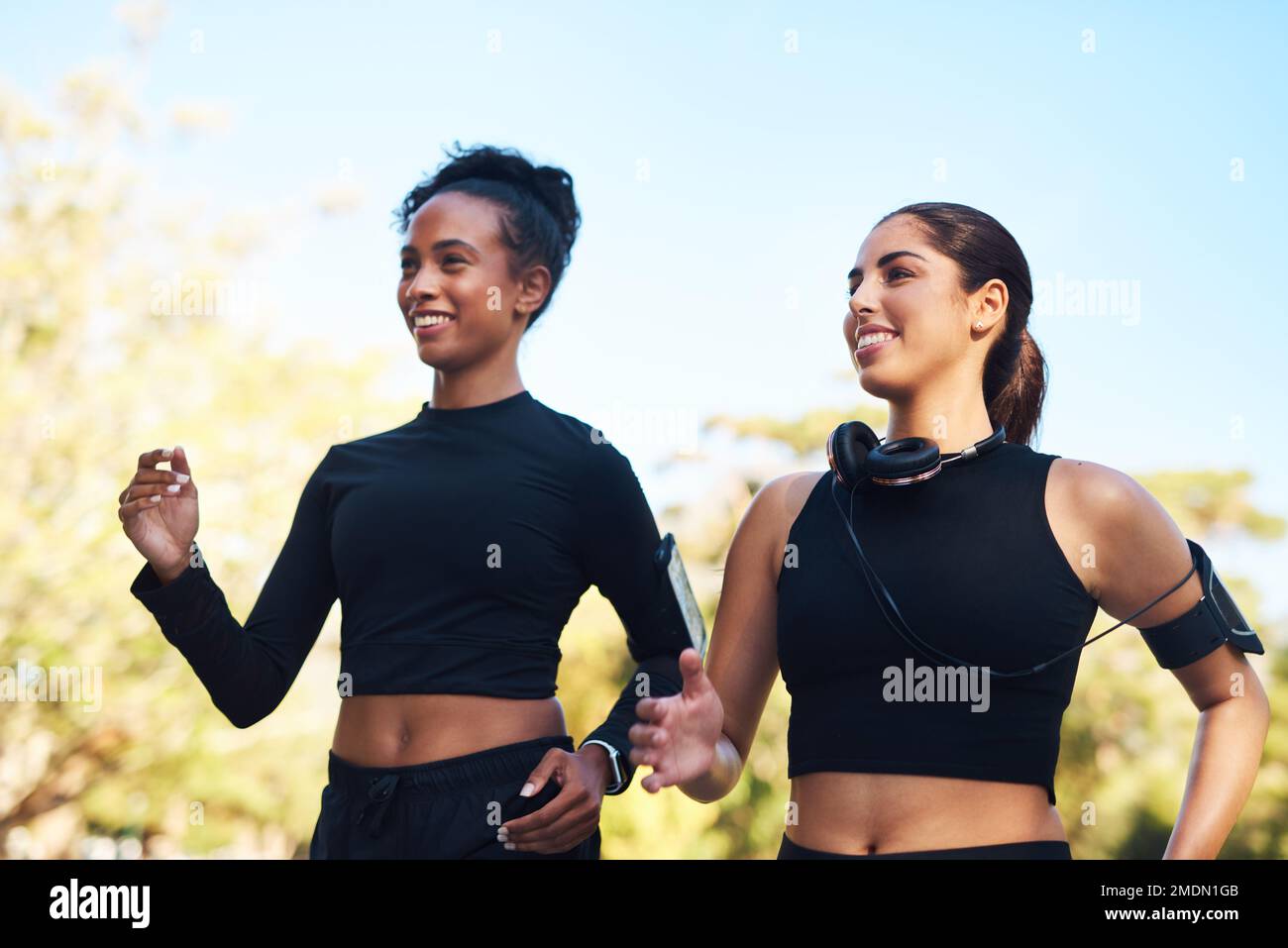 We follow each others pace. two attractive young women running next to ...