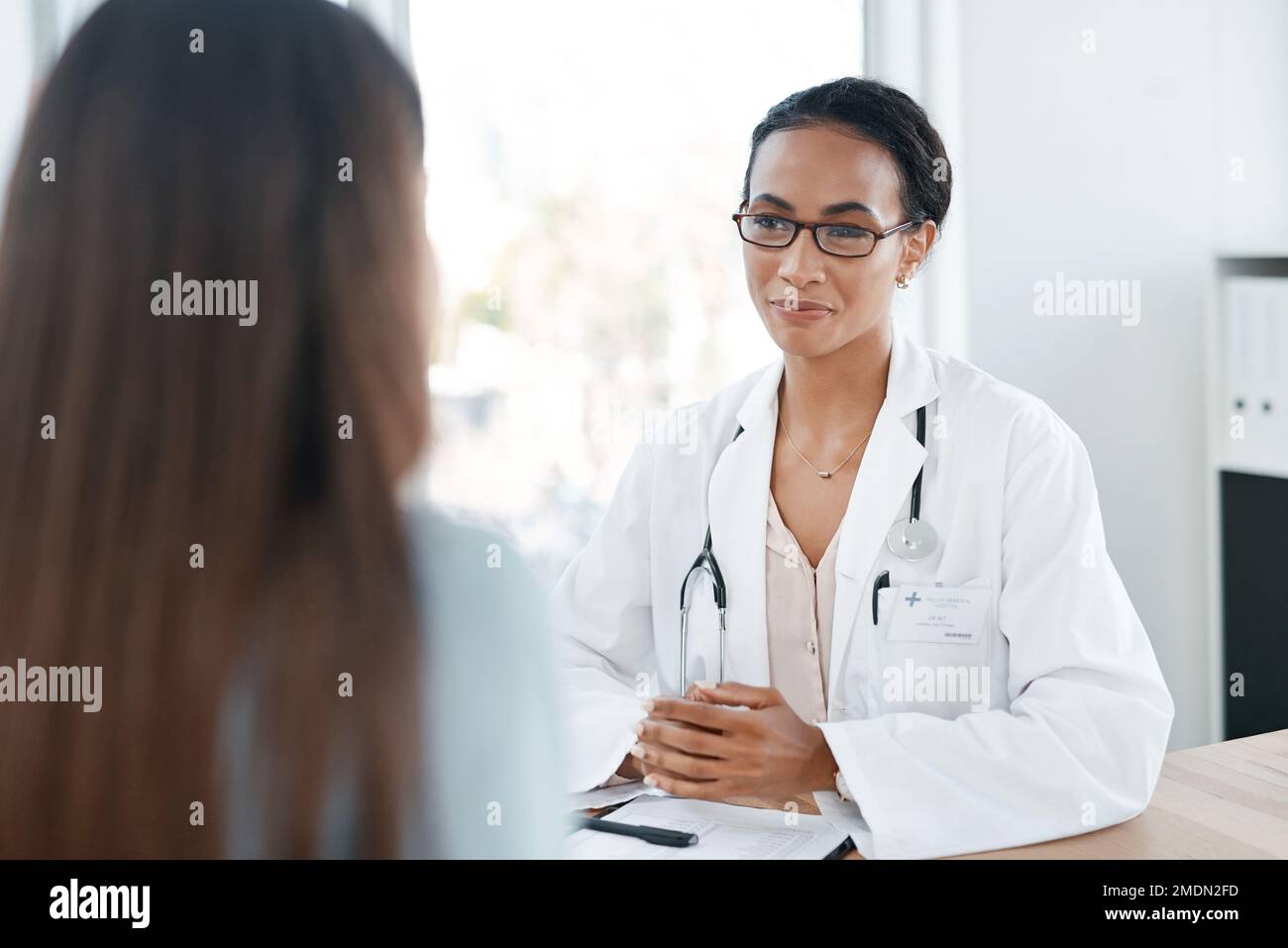 This is a safe space. a young doctor talking to her patient Stock Photo ...