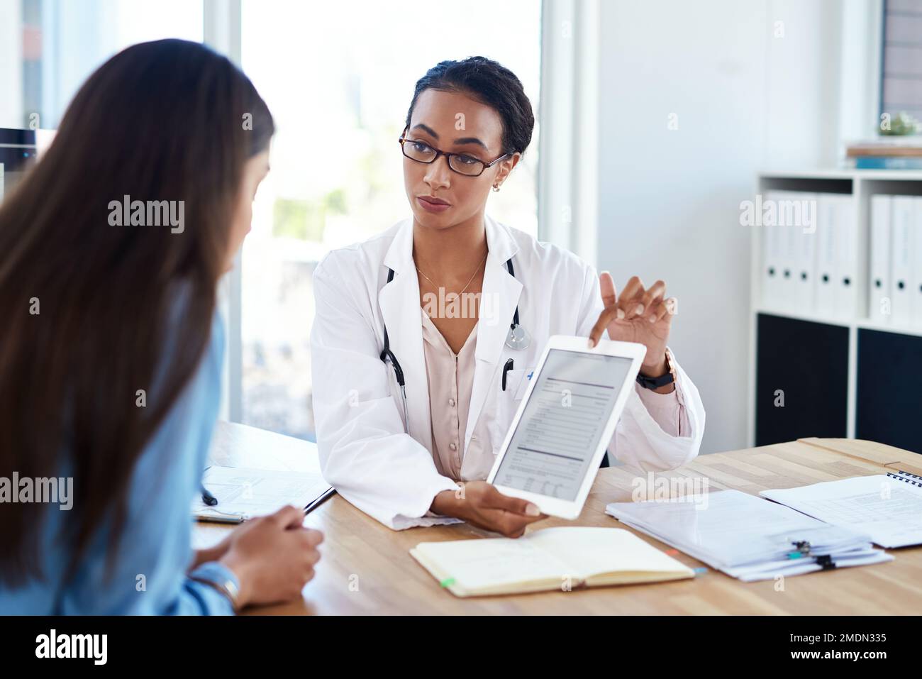 Doctor visits in the digital age. a young doctor using a digital tablet ...