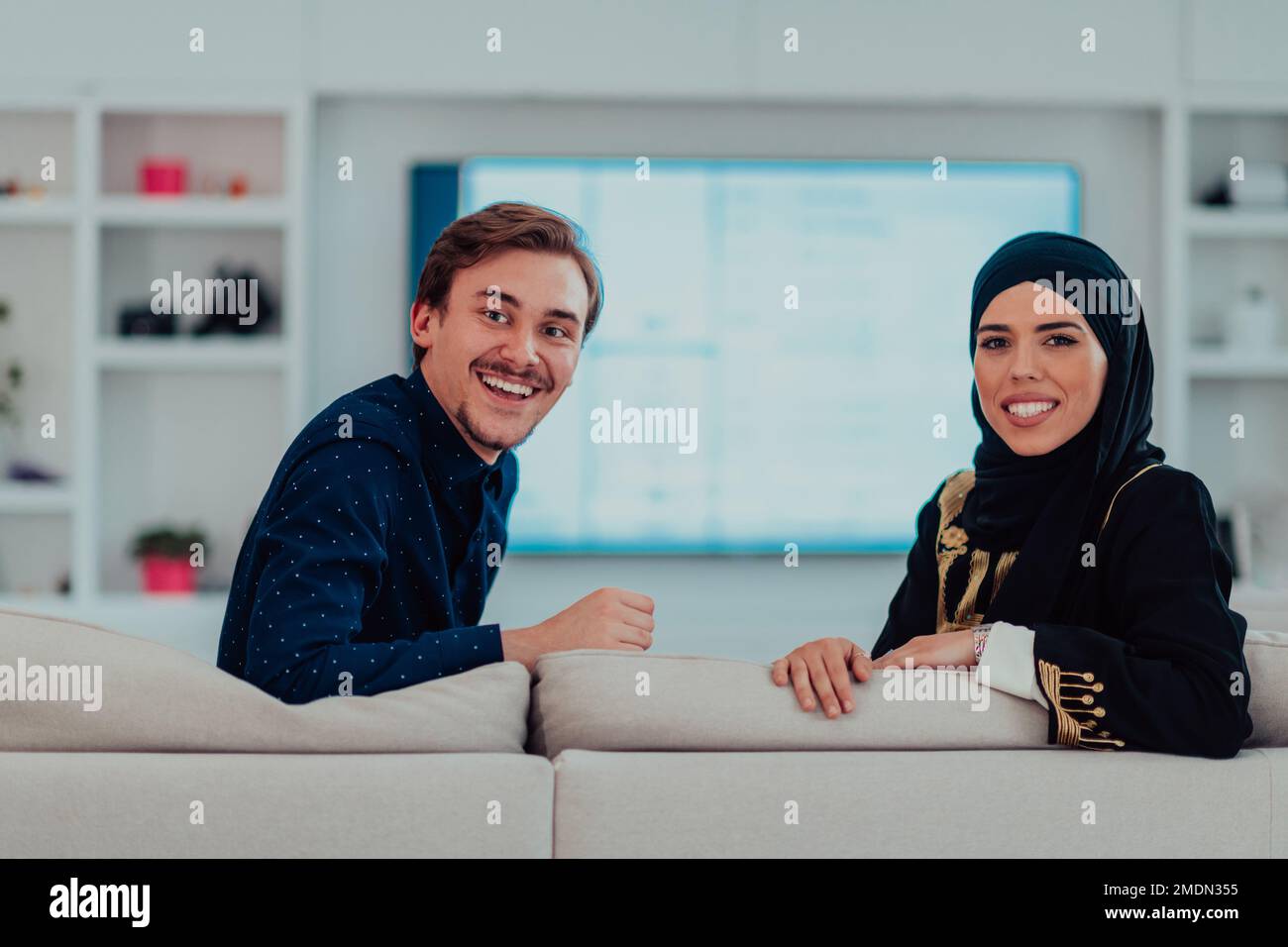 Young muslim couple woman wearing islamic hijab clothes sitting on sofa ...