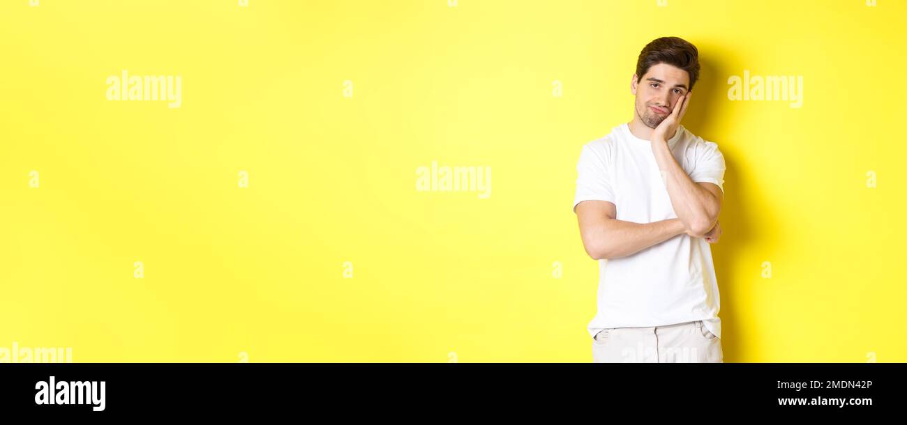 Bored and unamused man looking with indifference, standing in white ...