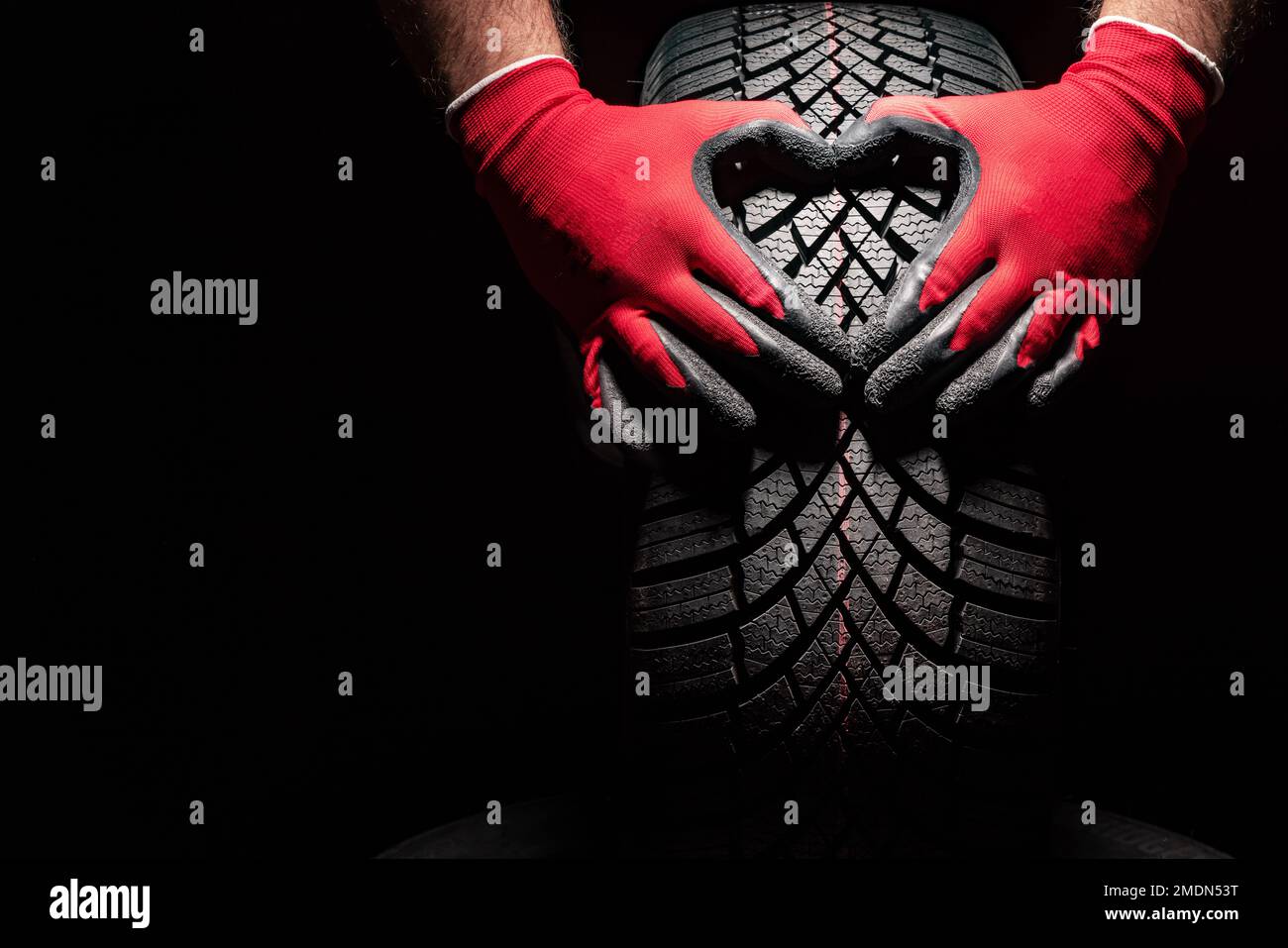 Car tire service and hands of mechanic holding new tyre on black ...