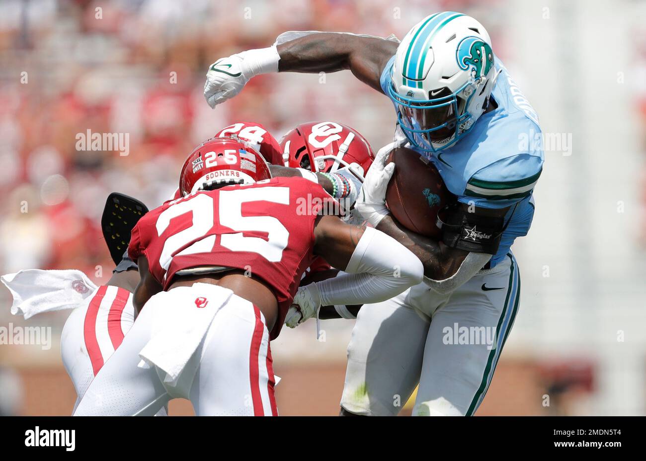 Tulane running back Cameron Carroll (20) works to escape a tackle by ...