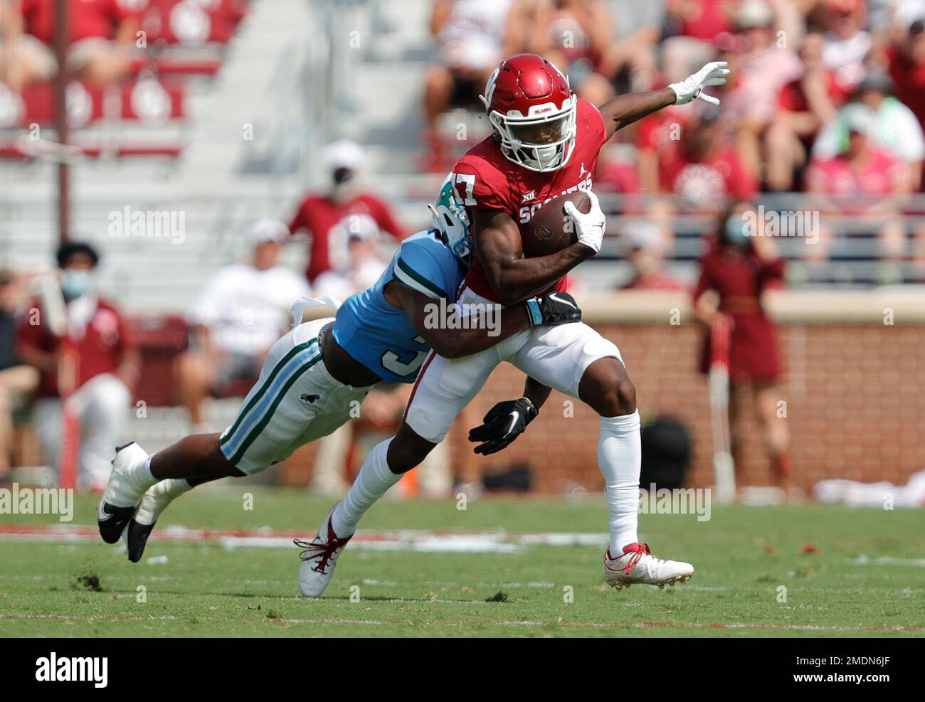 Oklahoma wide receiver Marvin Mims (17) fights off a tackle by Tulane ...