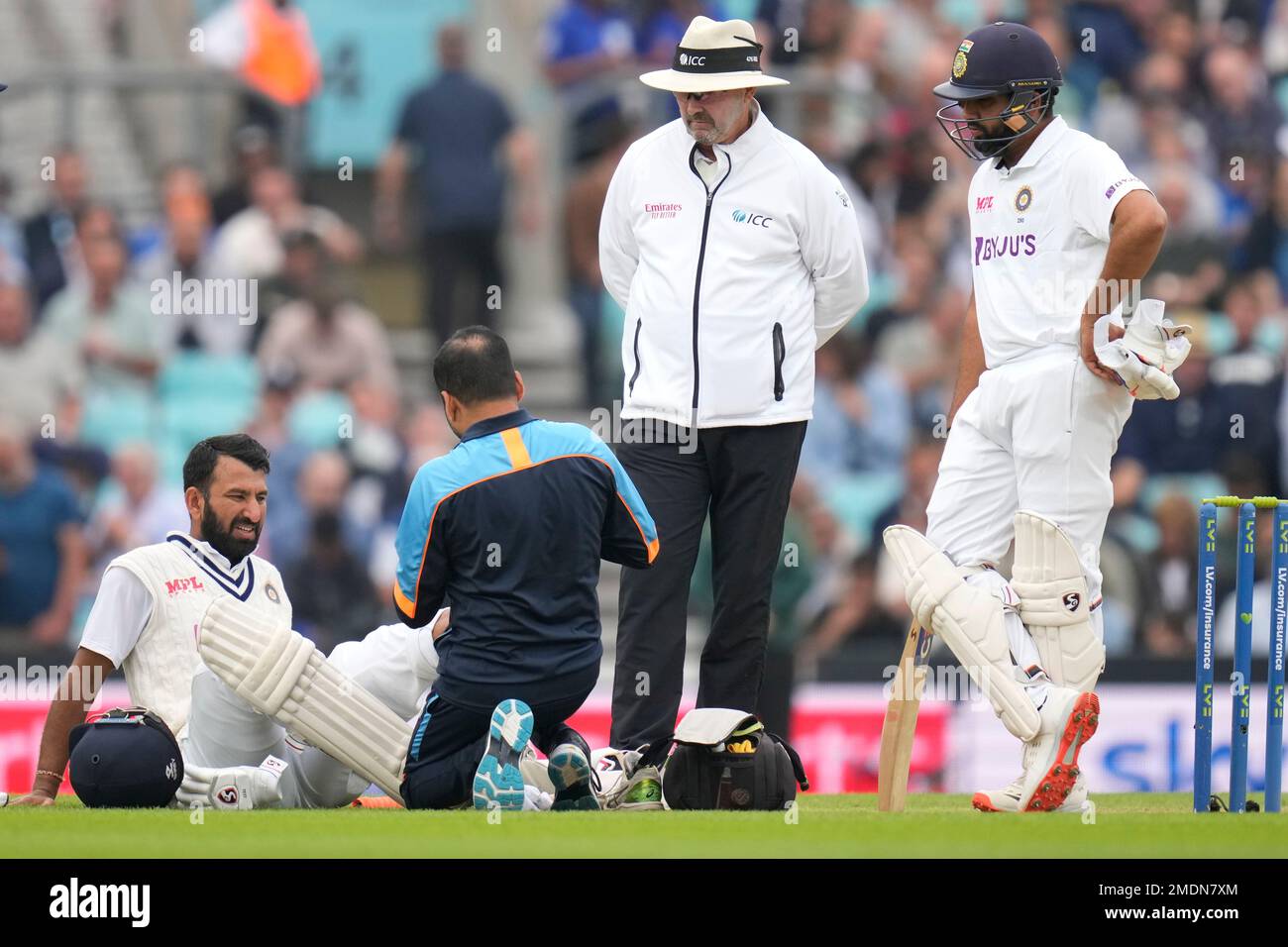 India's Cheteshwar Pujara receives treatment after he is injured on day ...