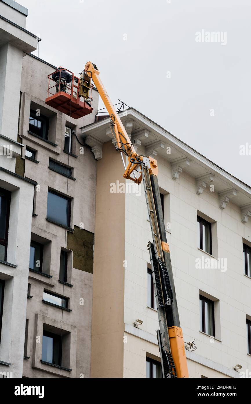 Construction worker in lift bucket of crane restore and repair historic ...