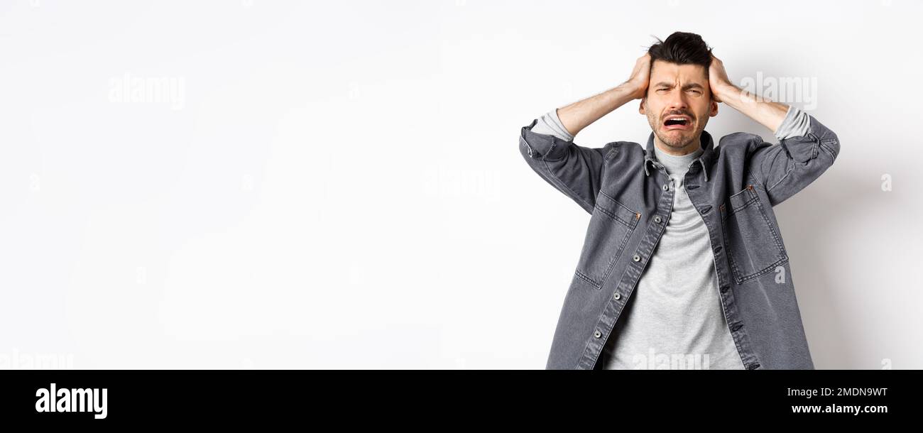 Frustrated guy crying and panicking, holding hands on head and ...