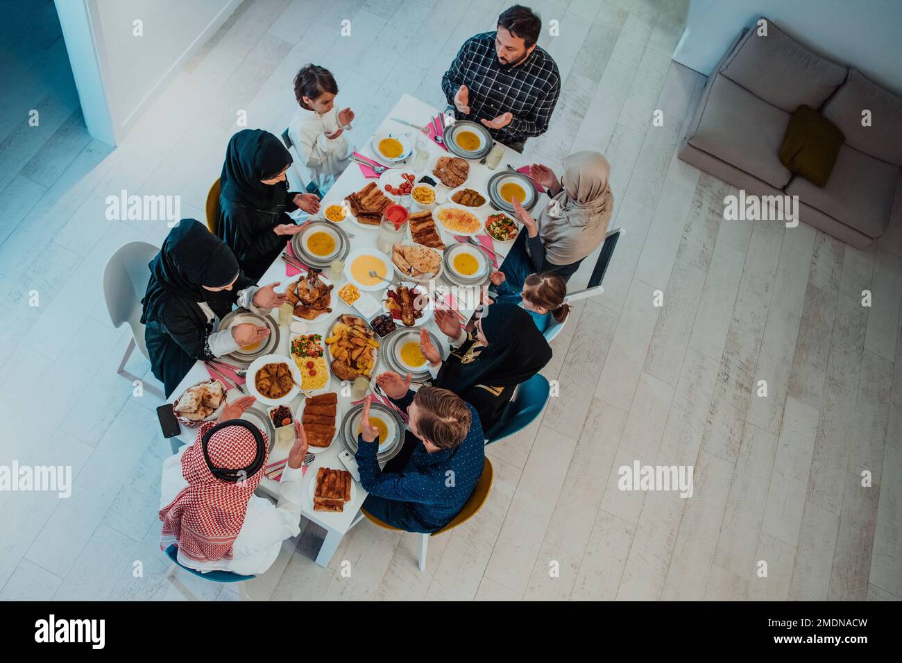 Top view of Muslim family having Iftar dinner drinking water to break ...