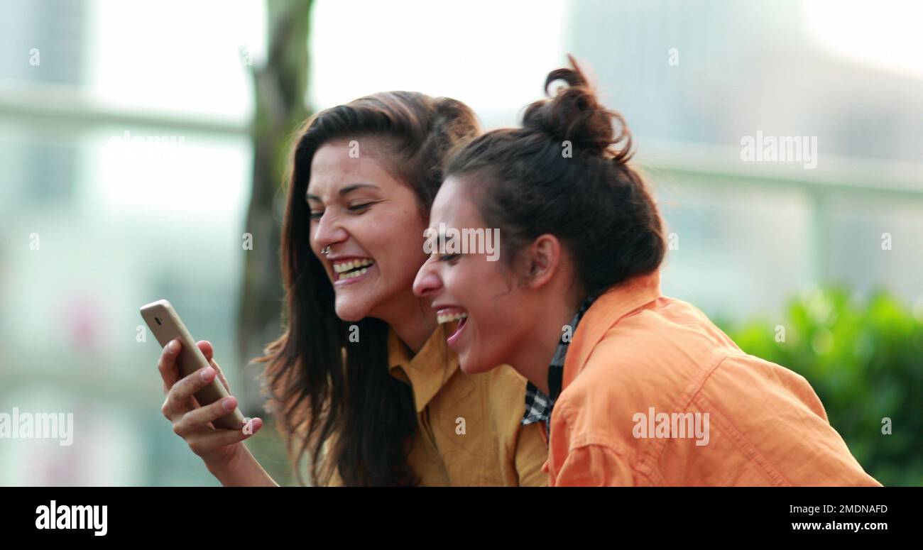 Women reaction laughing out loud. Two young women laughing together to ...