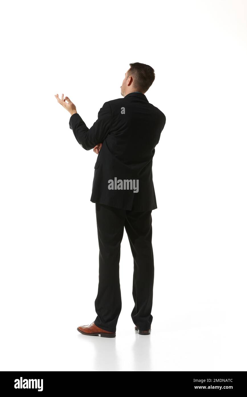 Back view. Businessman in a suit standing, thinking, considering ideas ...