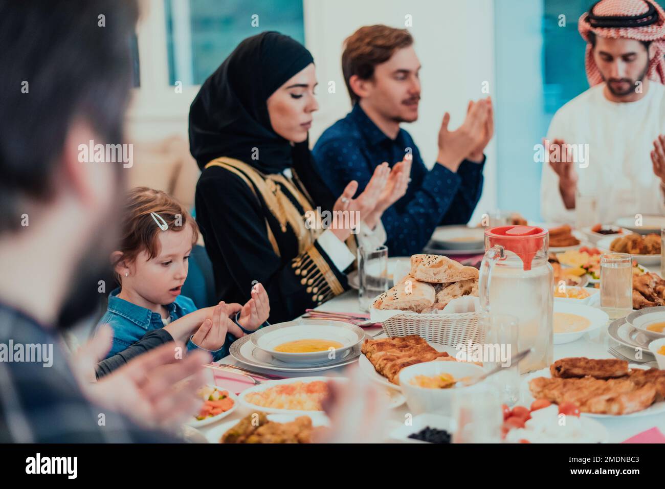 A Muslim family praying together, the Muslim prayer after breaking the ...