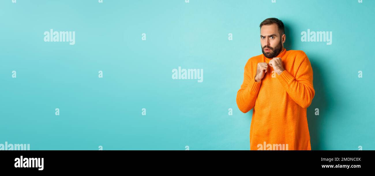 Scared guy jumping startled, looking at something scary, standing in ...