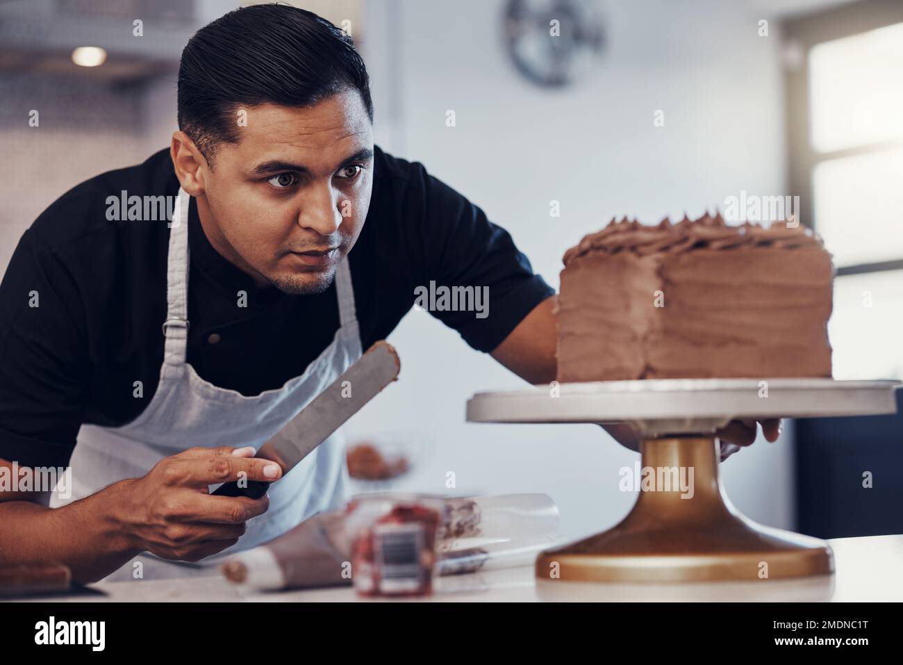 Baking, kitchen and man icing cake with chocolate frosting and piping ...