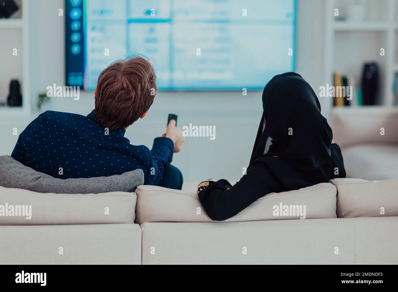 Young muslim couple woman wearing islamic hijab clothes sitting on sofa ...