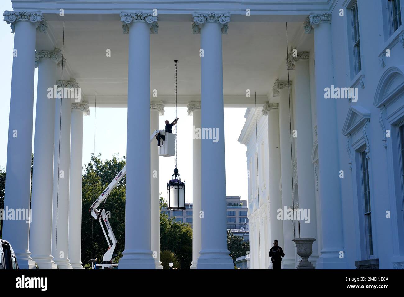 A worker works on the light fixture over the North Portico of the White ...