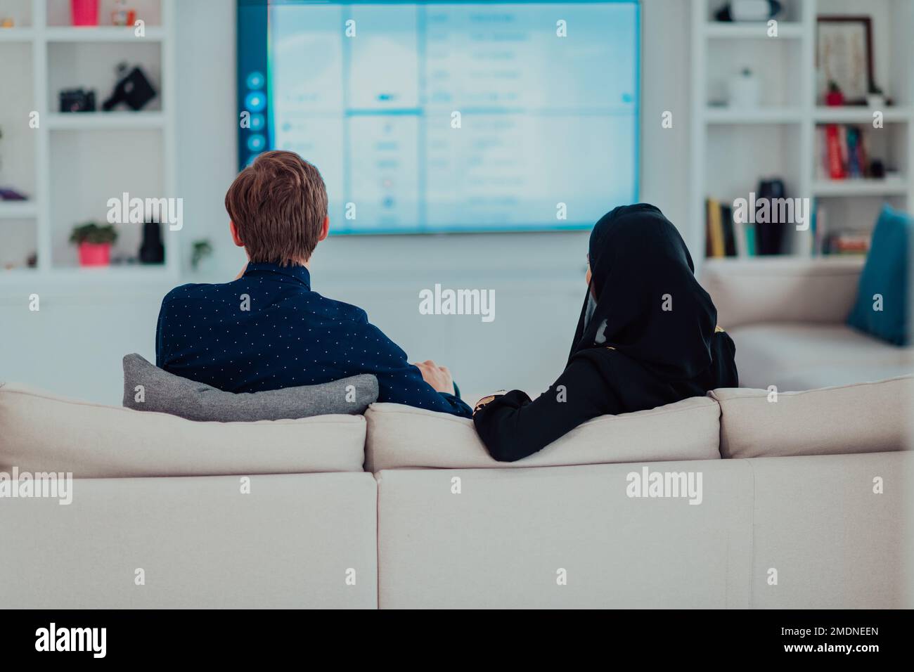 Young muslim couple woman wearing islamic hijab clothes sitting on sofa ...